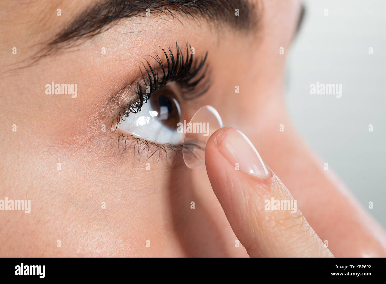 Closeup of young woman wearing contact lens at home Stock Photo - Alamy