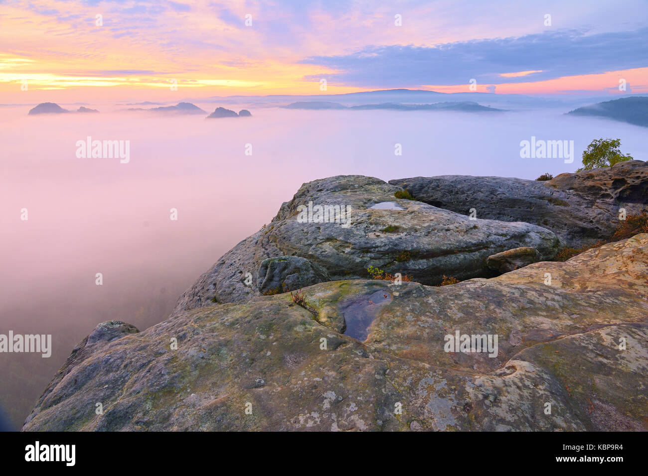 Strong sun rays make long strips in the mist. Autumn sunny view over ...