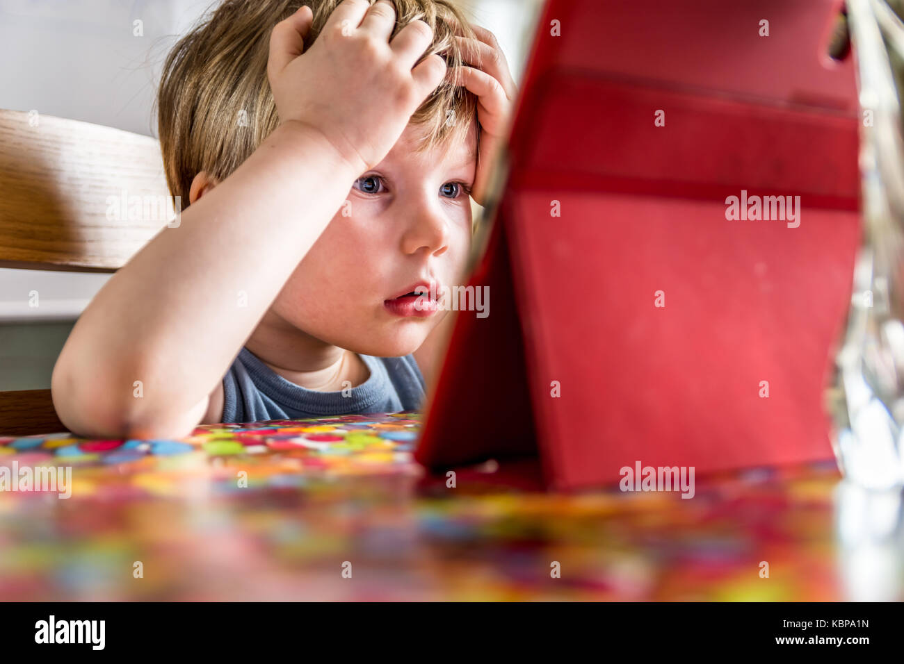 Little Boy watching digital tablet with face expression Stock Photo - Alamy