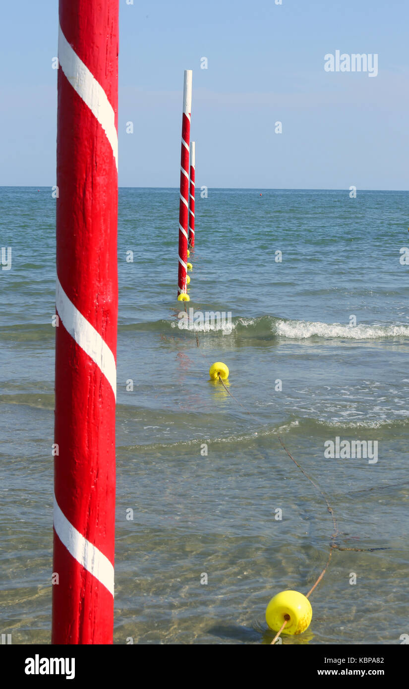 white and red colored poles on the sea to moor the boats Stock Photo ...