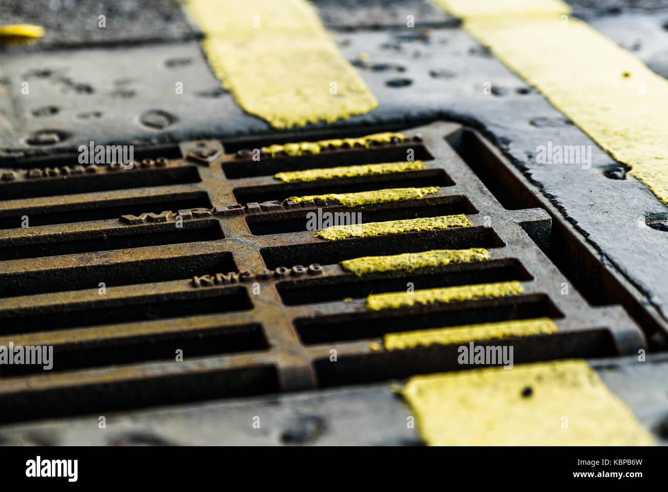 Closeup view of yellow road marking on sewer grate Stock Photo - Alamy