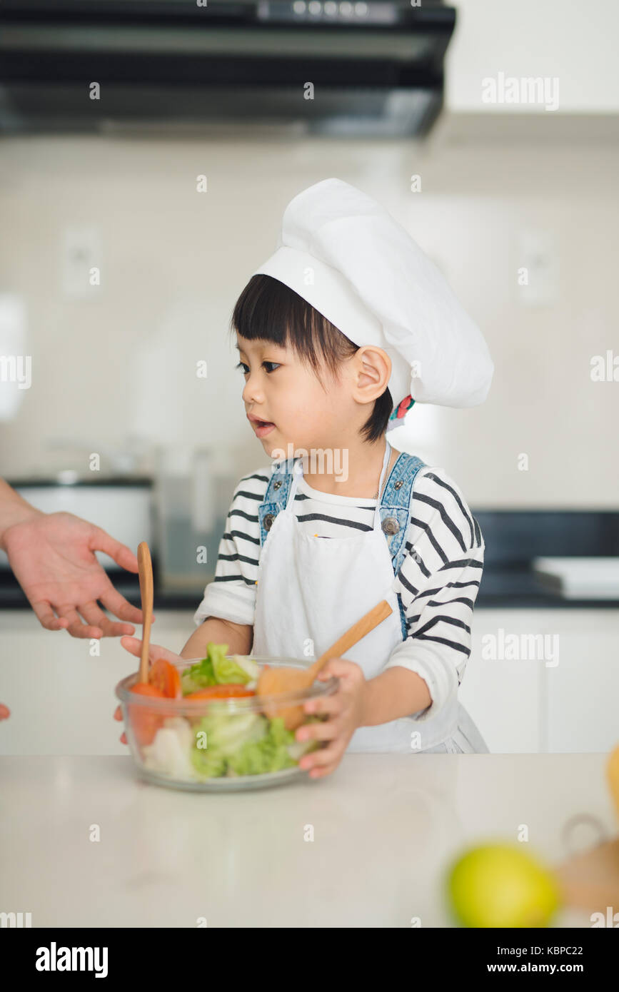 Child helping mother cooking in modern kitchen Stock Photo - Alamy