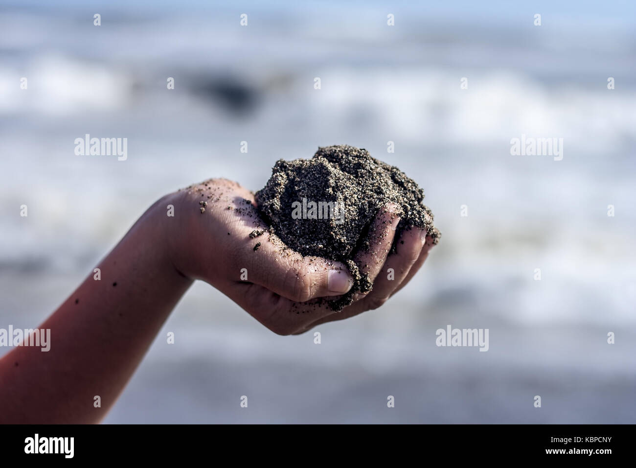 A hand holding sea sand Stock Photo - Alamy
