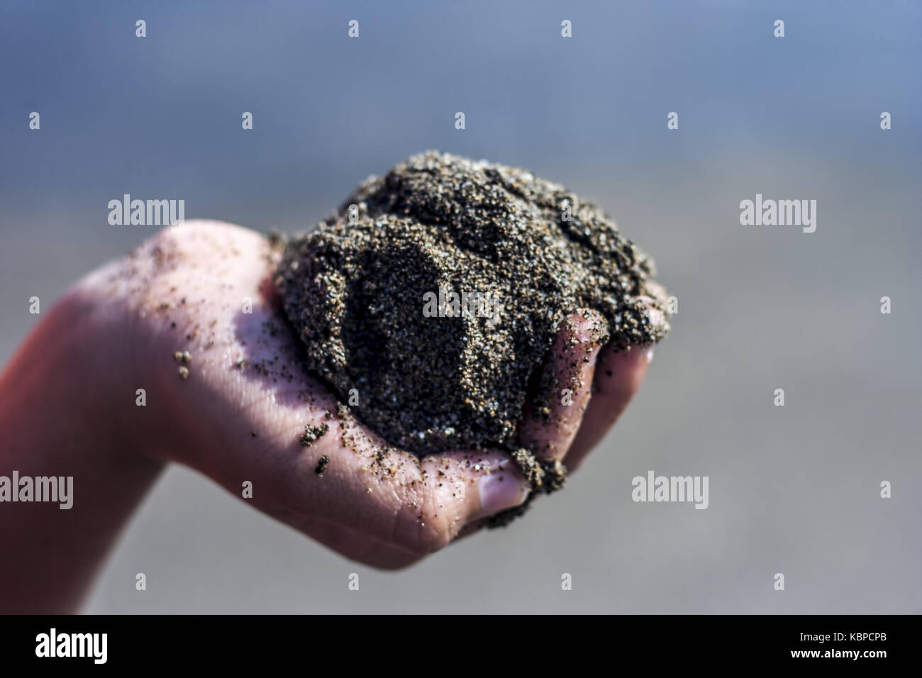 A hand holding sea sand Stock Photo - Alamy