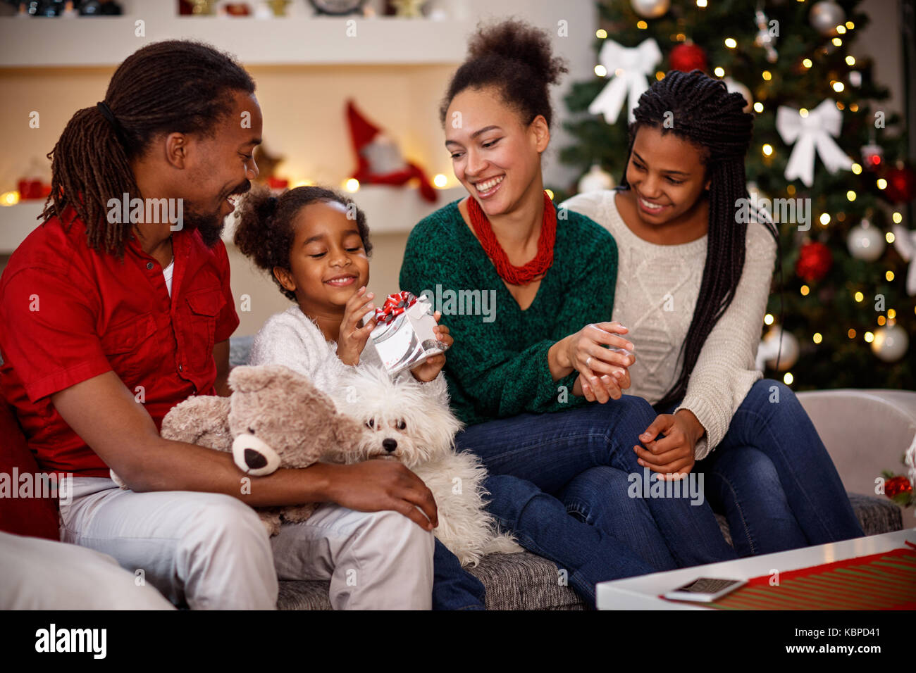 Cute child receiving Christmas gift from her family Stock Photo - Alamy