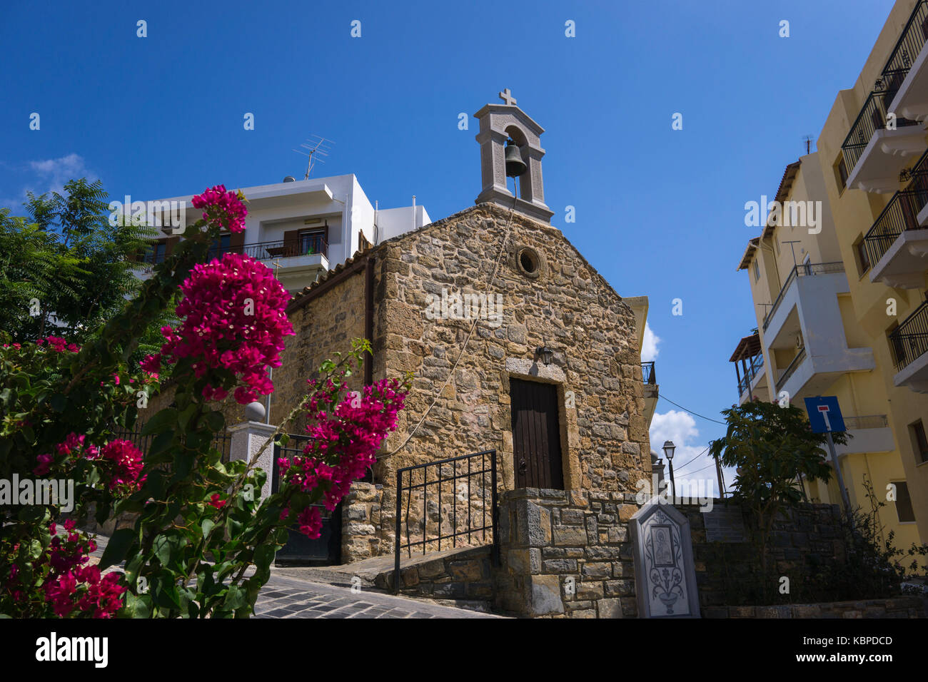 Little church in greece with blue sky and beautiful flower in the front ...