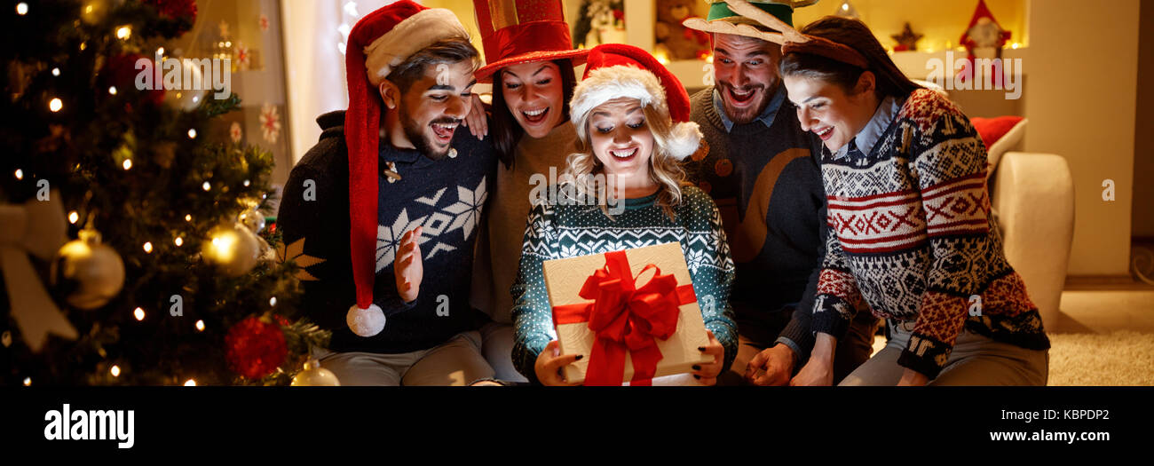 Girl with friends and shiny gift on Christmas eve Stock Photo - Alamy