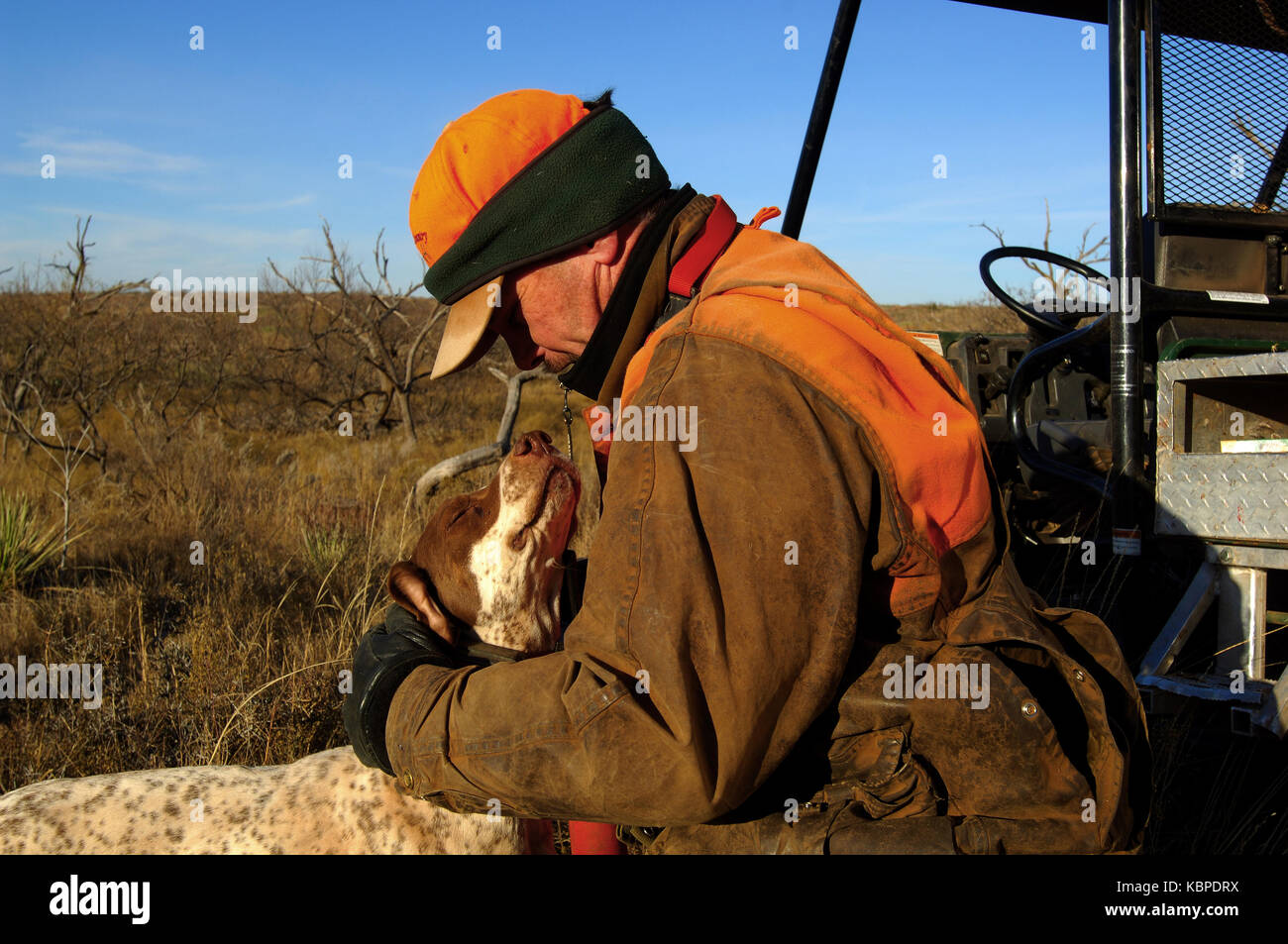 A quail hunter embracing his English Pointer hunting dog in West Texas ...
