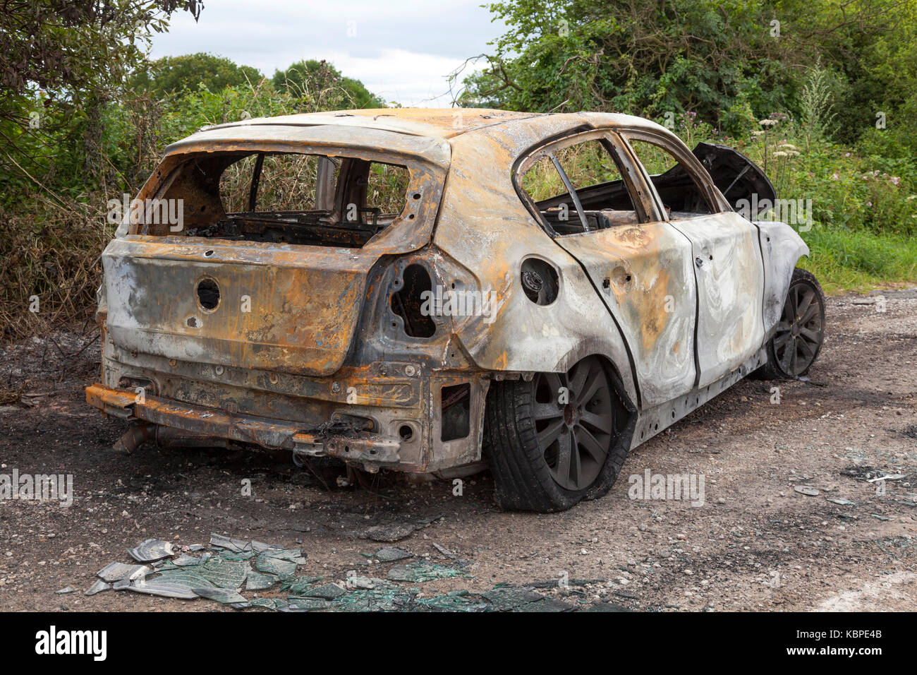 A burnt out BMW in a lay by in the UK Stock Photo - Alamy