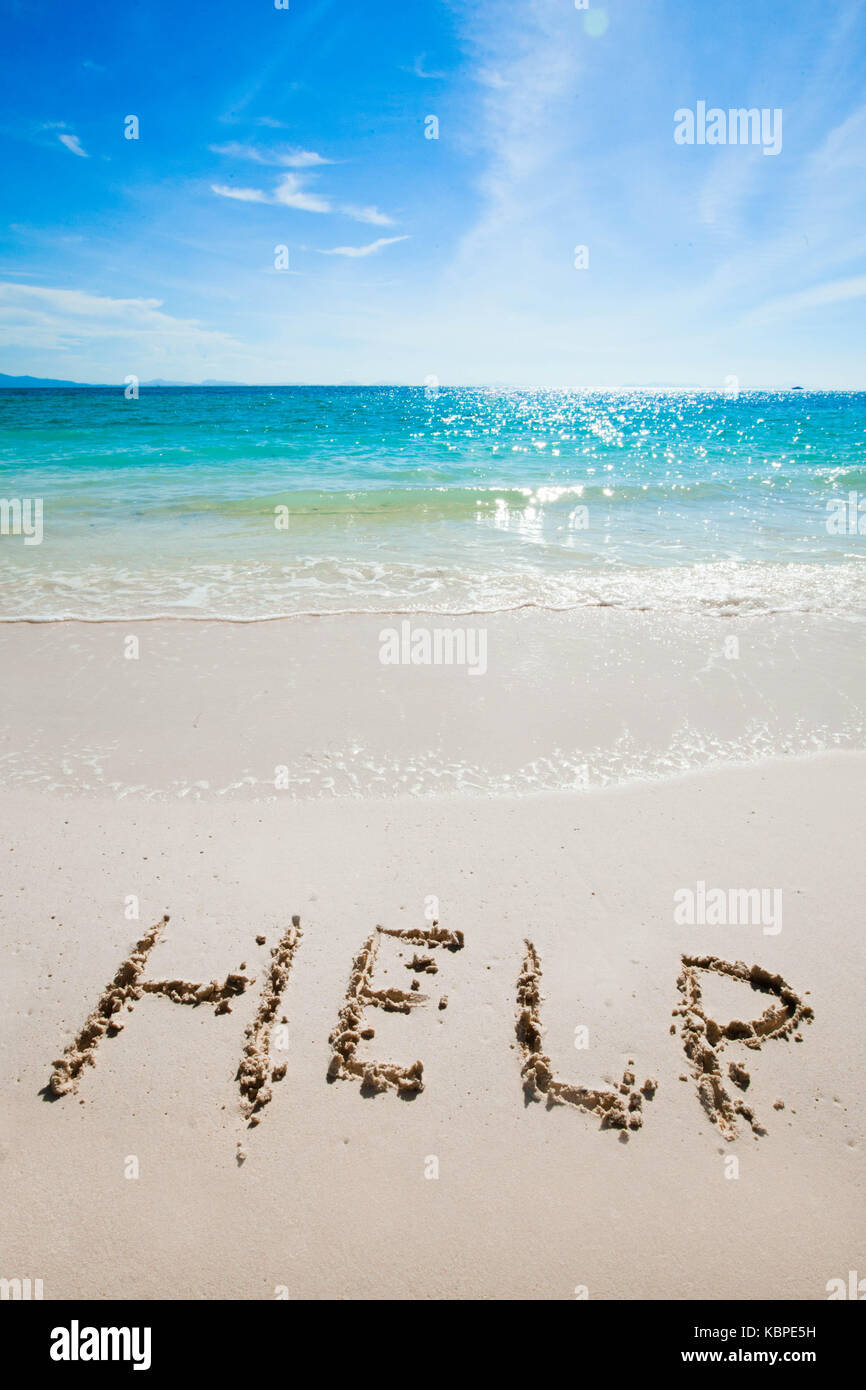 Help Sign on the beach written on sand Stock Photo - Alamy
