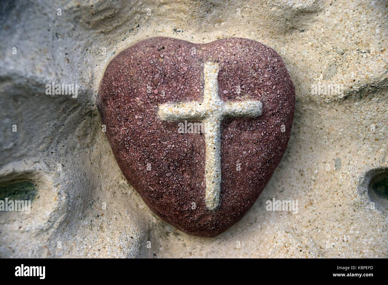 a red heart made of sandstone, a cross in the middle, Symbol of love ...