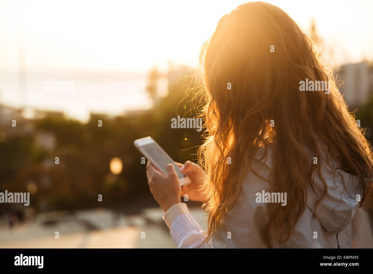 Side view of brunette woman in autumn clothes writing message on her ...