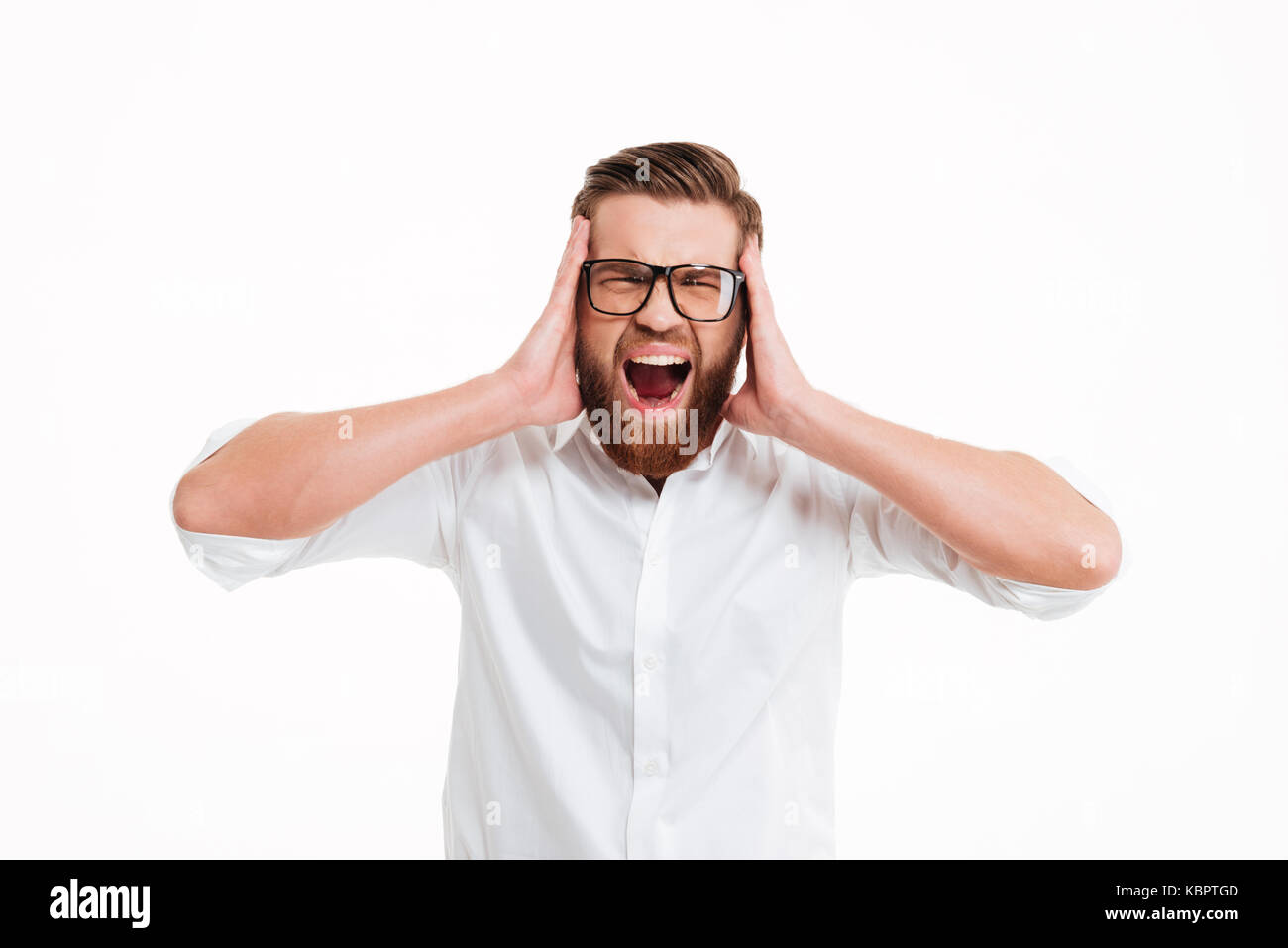 Image of screaming angry young bearded man standing over white wall ...