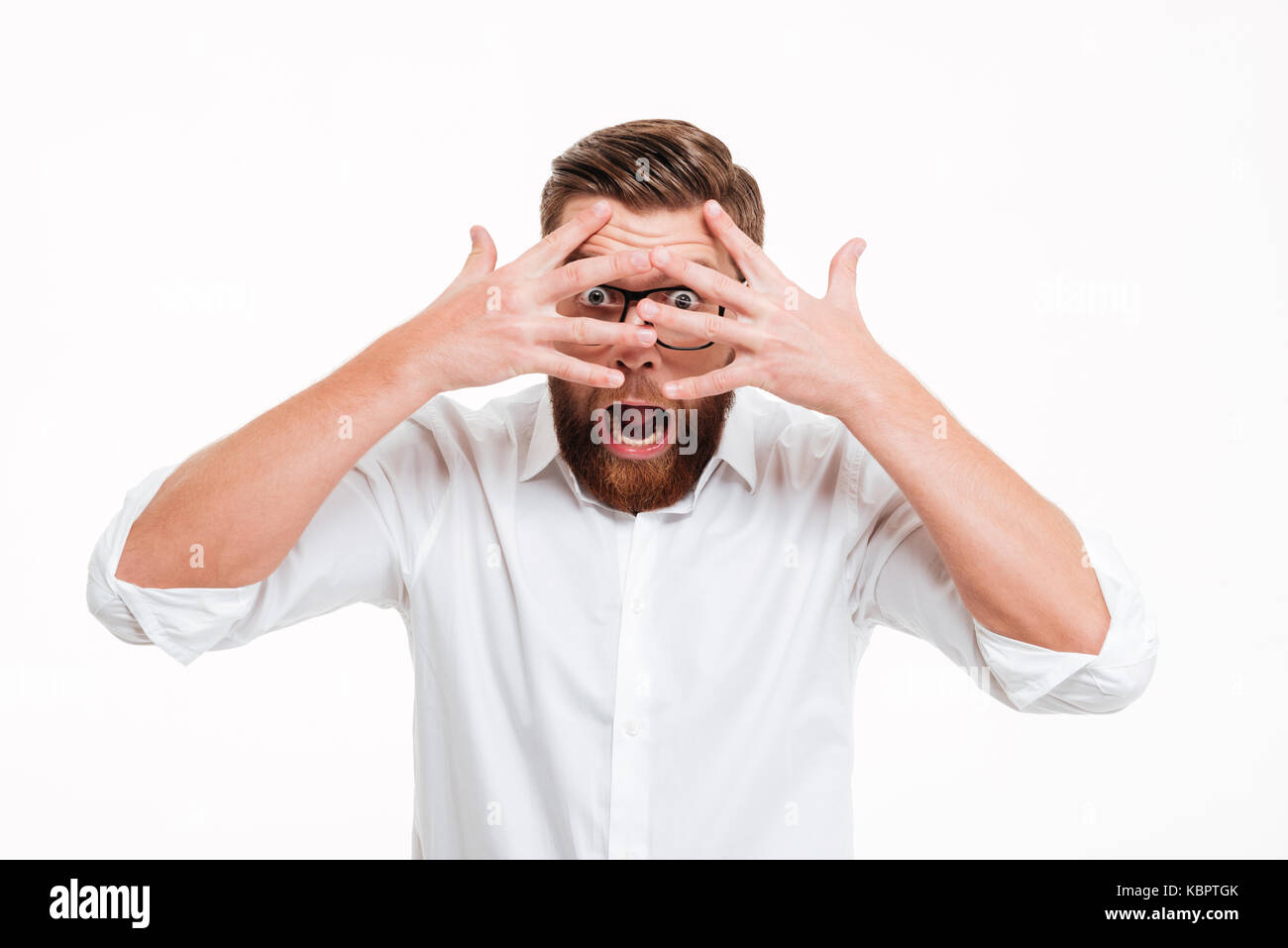 Picture of screaming scared young bearded man standing over white wall ...