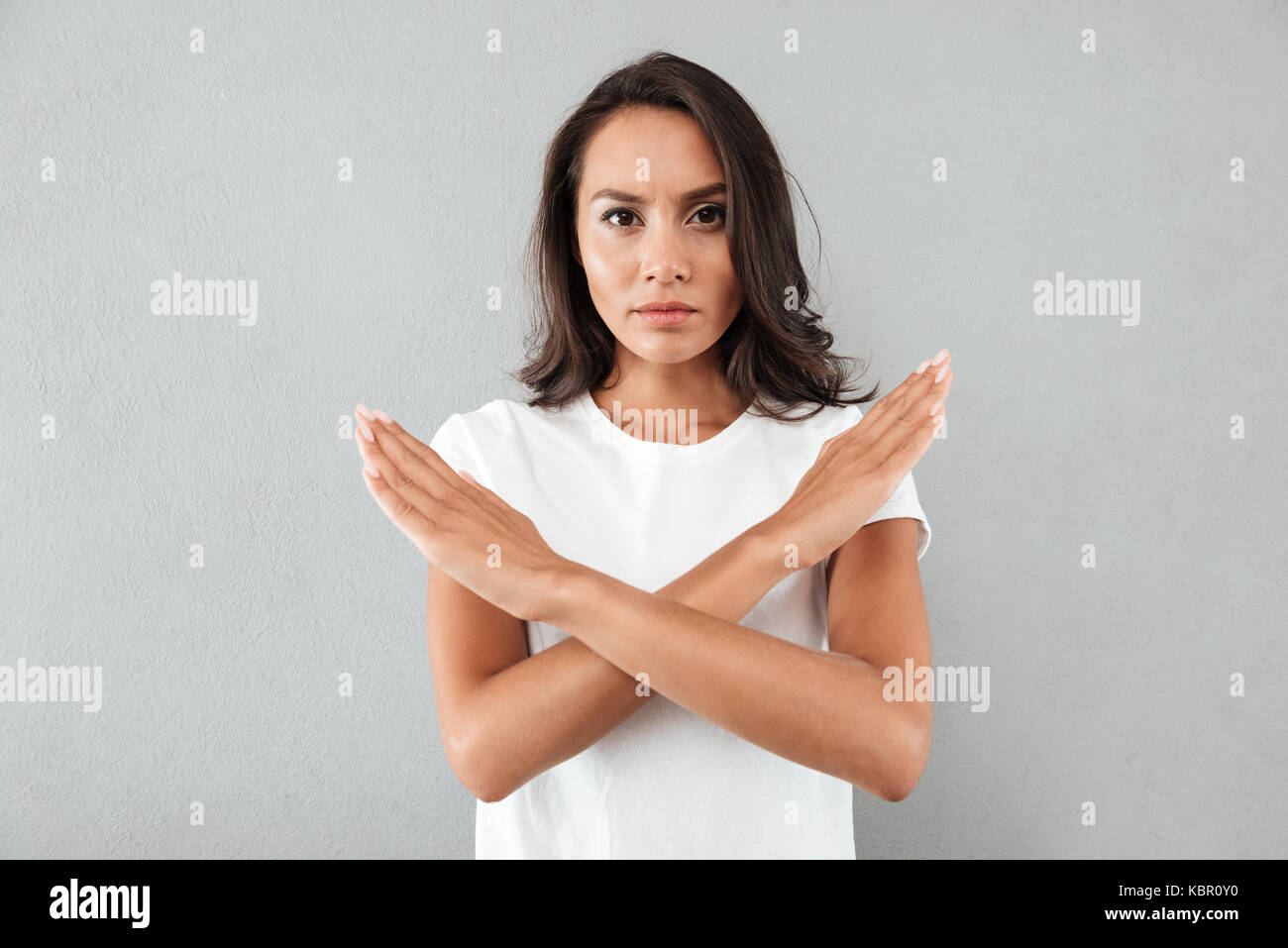 Angry serious asian woman showing crossed hands gesture and looking at ...