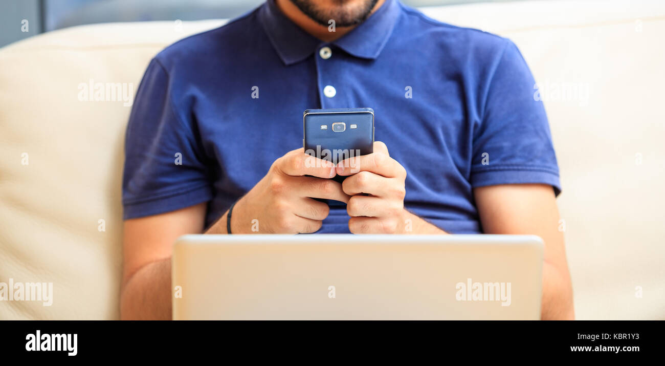 Young man looking at his smart phone, closeup on the hands Stock Photo ...