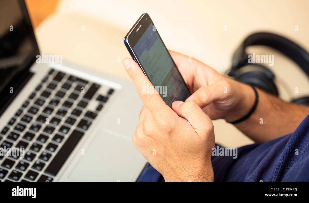 Young man looking at his smart phone, closeup on the hands Stock Photo ...