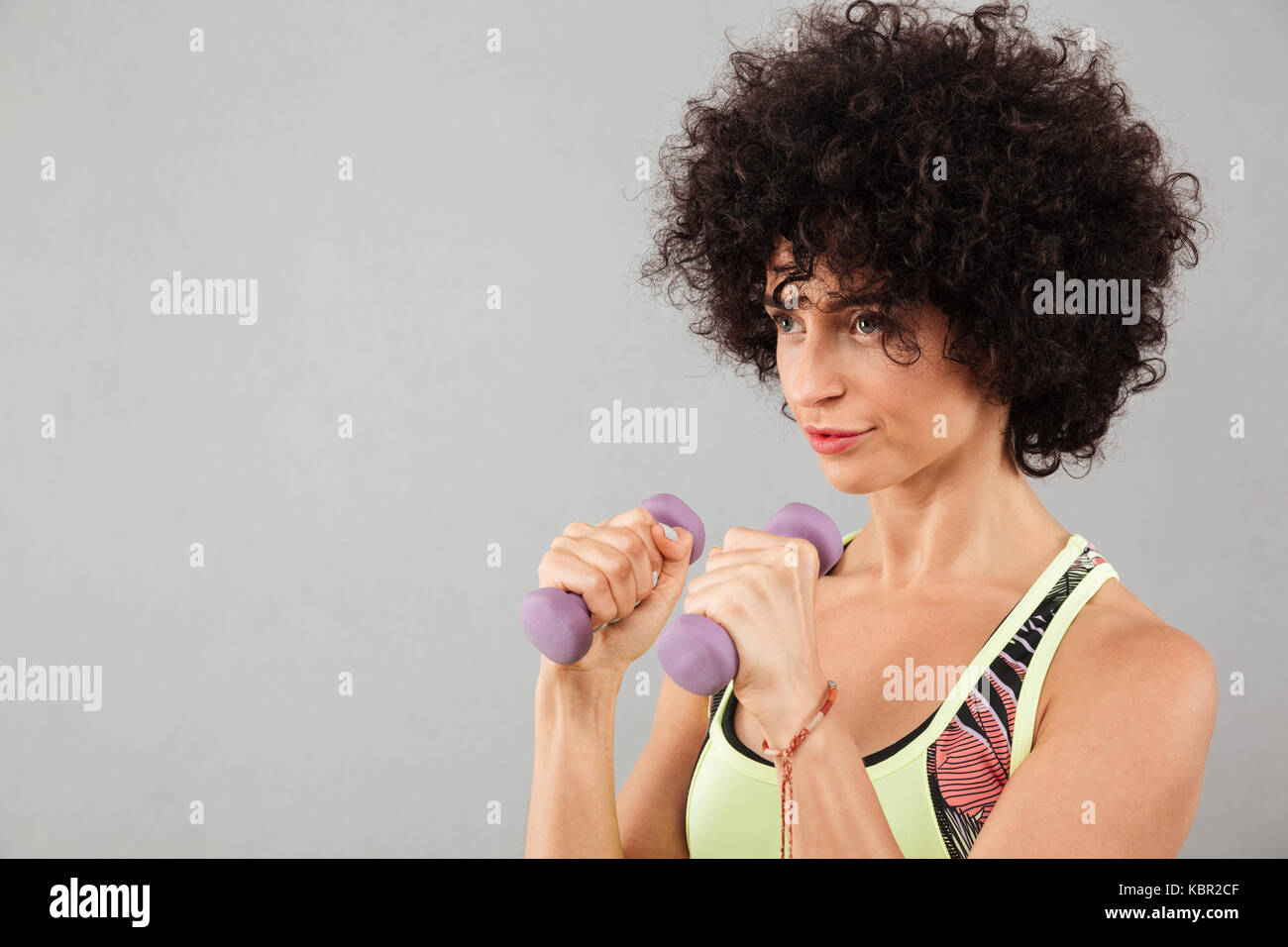 Close up picture of Concentrated curly fitness woman doing exercise ...