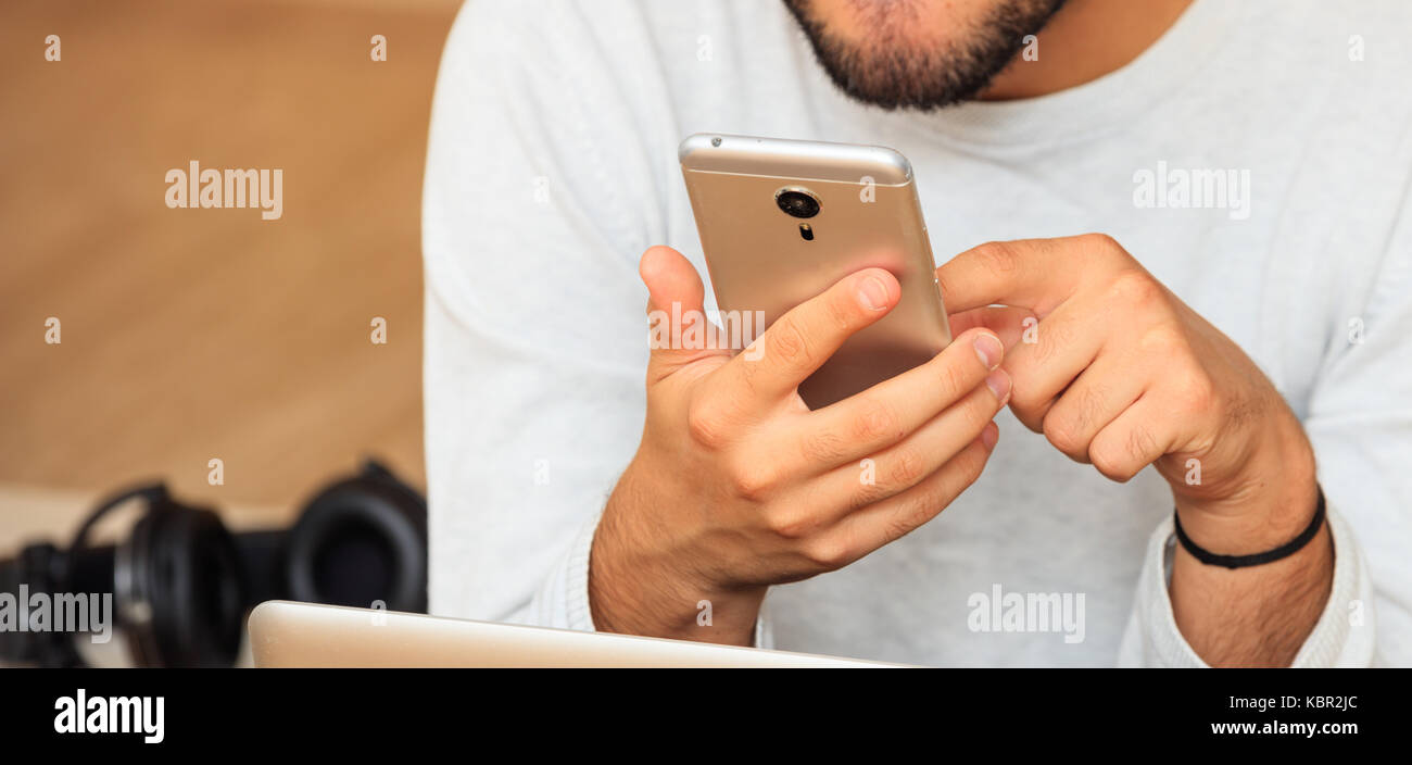 Young man looking at his smart phone, closeup on the hands Stock Photo ...