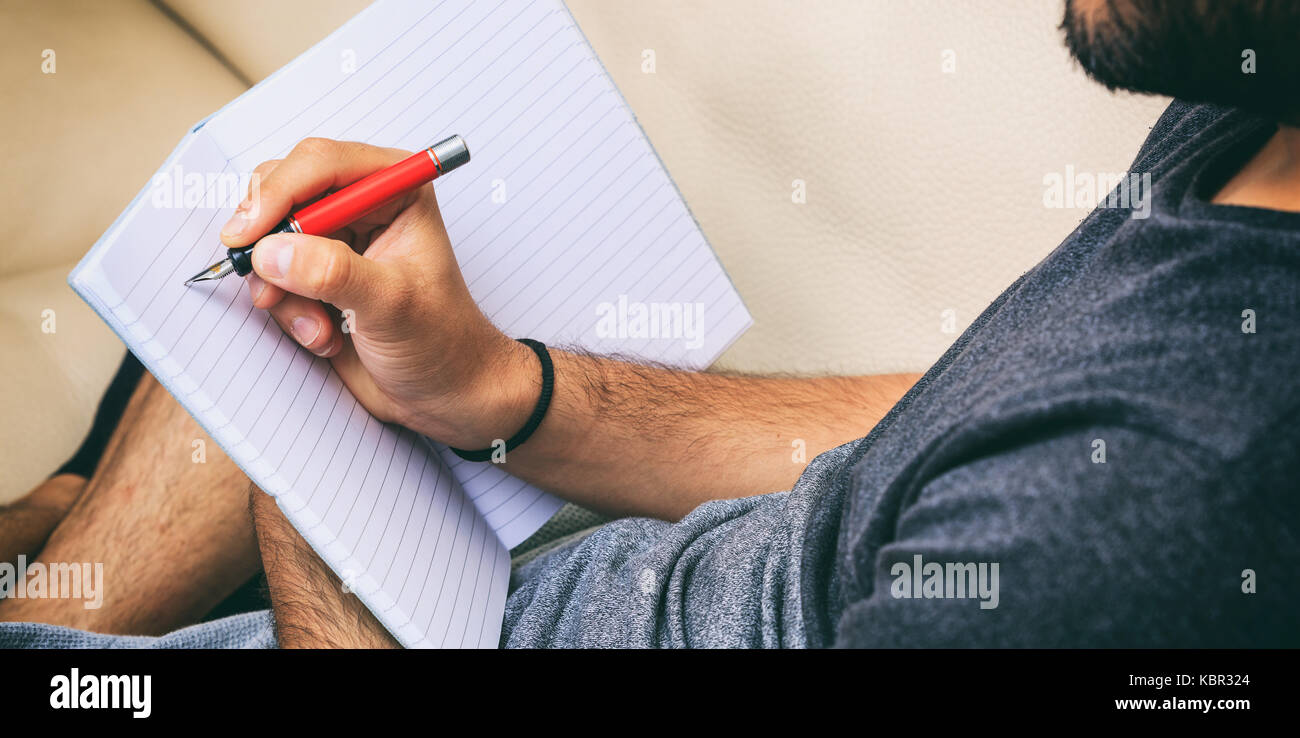 Modern workspace at home. Young man making notes, sitting on a leather ...