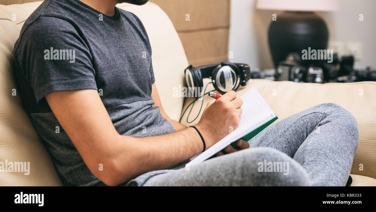 Modern workspace at home. Young man making notes, sitting on a leather ...