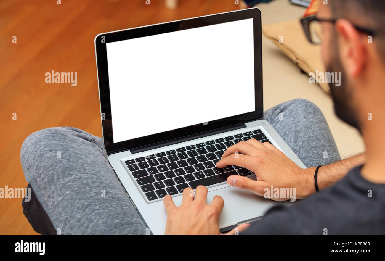 Young man working with a white screen laptop at home, copy space Stock ...