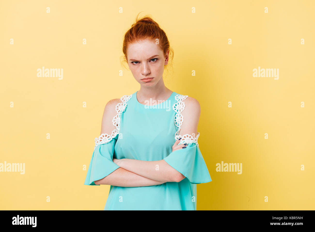 Angry ginger woman in dress holding crossed arms and looking at the ...