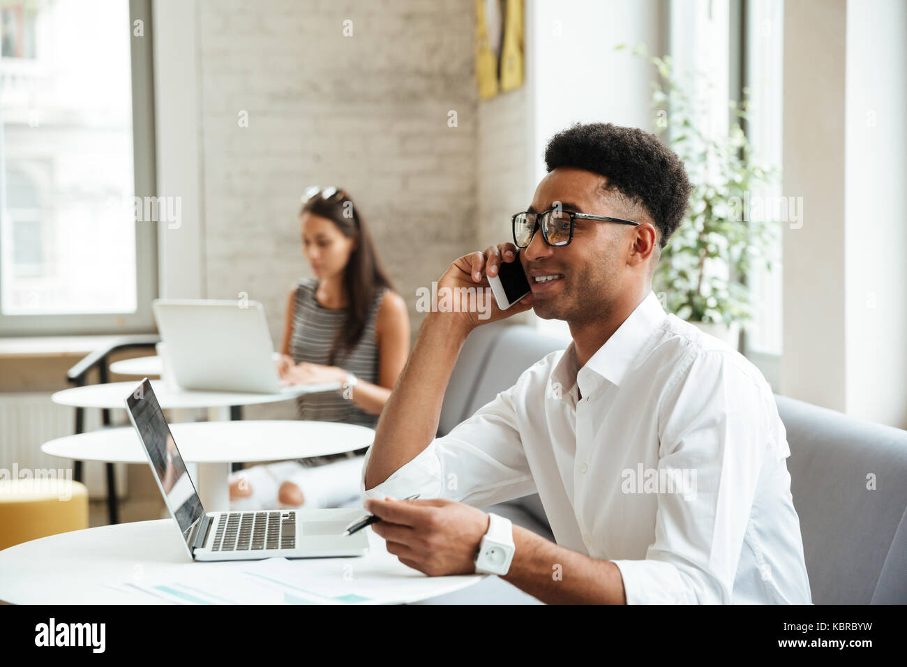 Image of concentrated young african man sitting coworking by laptop ...