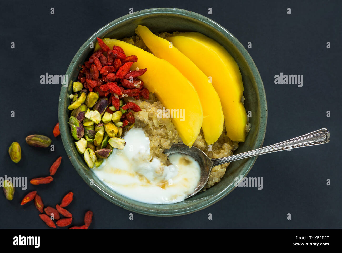 Quinoa porridge with mango, pistachio nuts, goji berries and honey ...