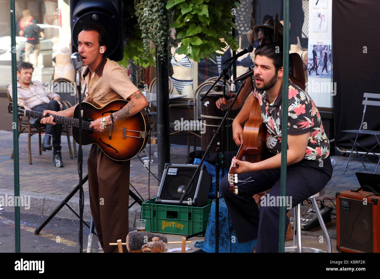 Trio of musicians with guitars and singing at an open air event, in ...