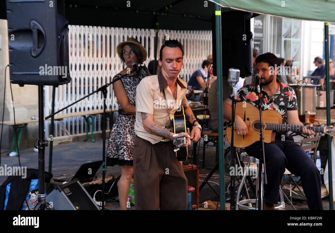Trio of musicians with guitars and singing at an open air event, in ...