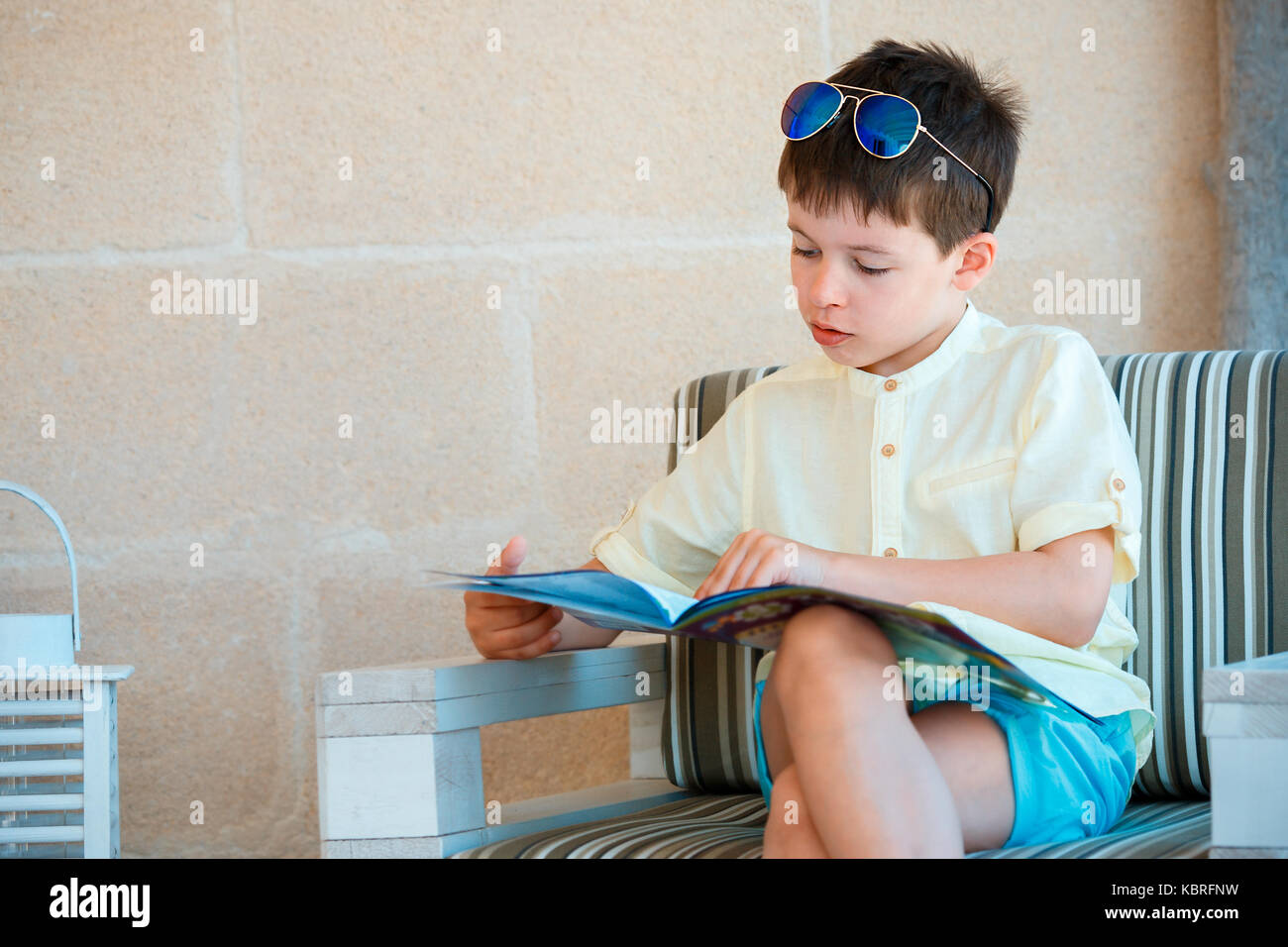 Young boy reading a book on outdoor terrace Stock Photo - Alamy