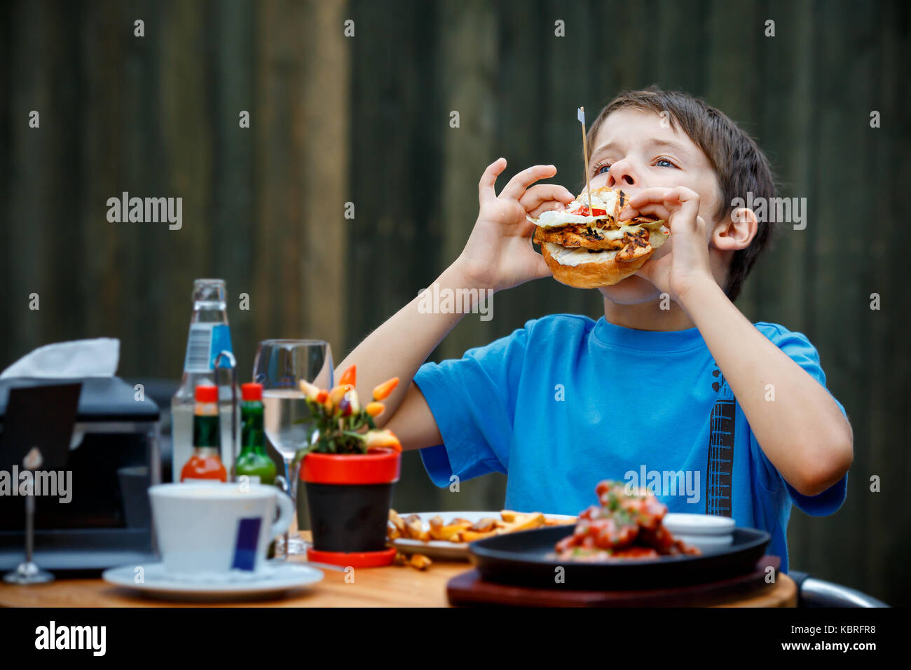 Cute healthy teenager boy eats hamburger and potato Stock Photo - Alamy