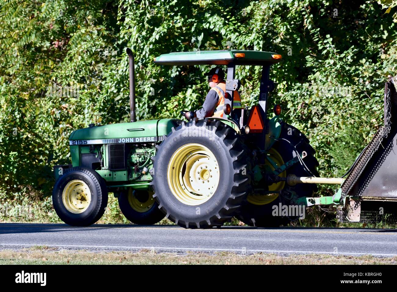 Farmer driving John Deere tractor down a road Stock Photo - Alamy