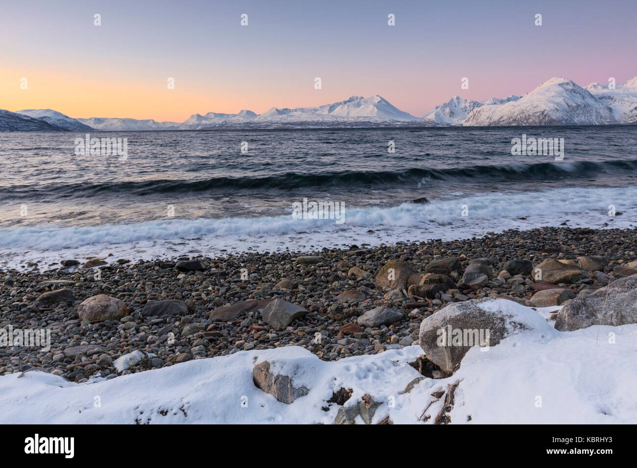 The waves breaking on a beach overlooking the Lyngen Alps during ...