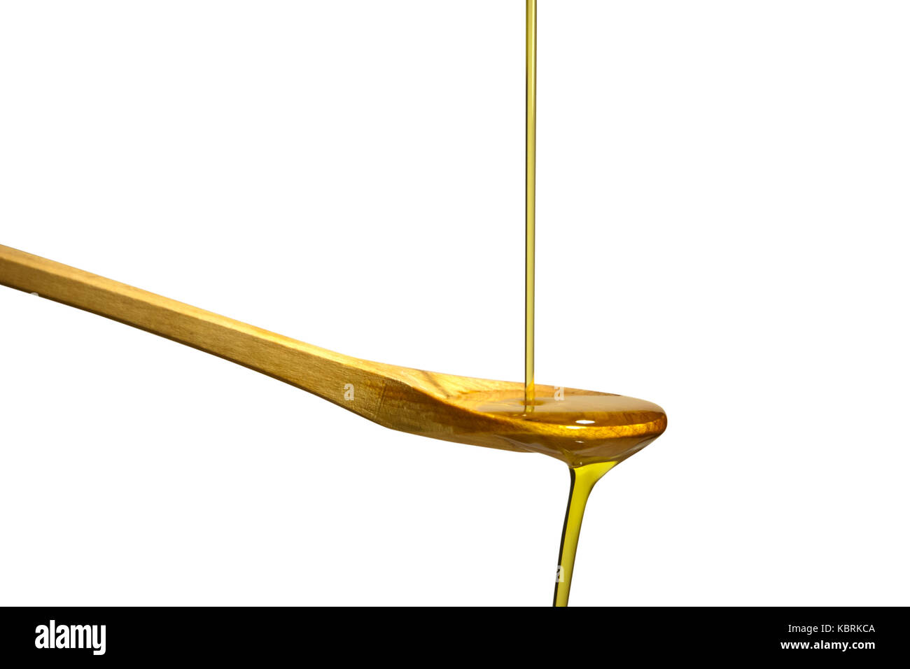 Olive oil running over the wooden spoon, isolated on white background ...
