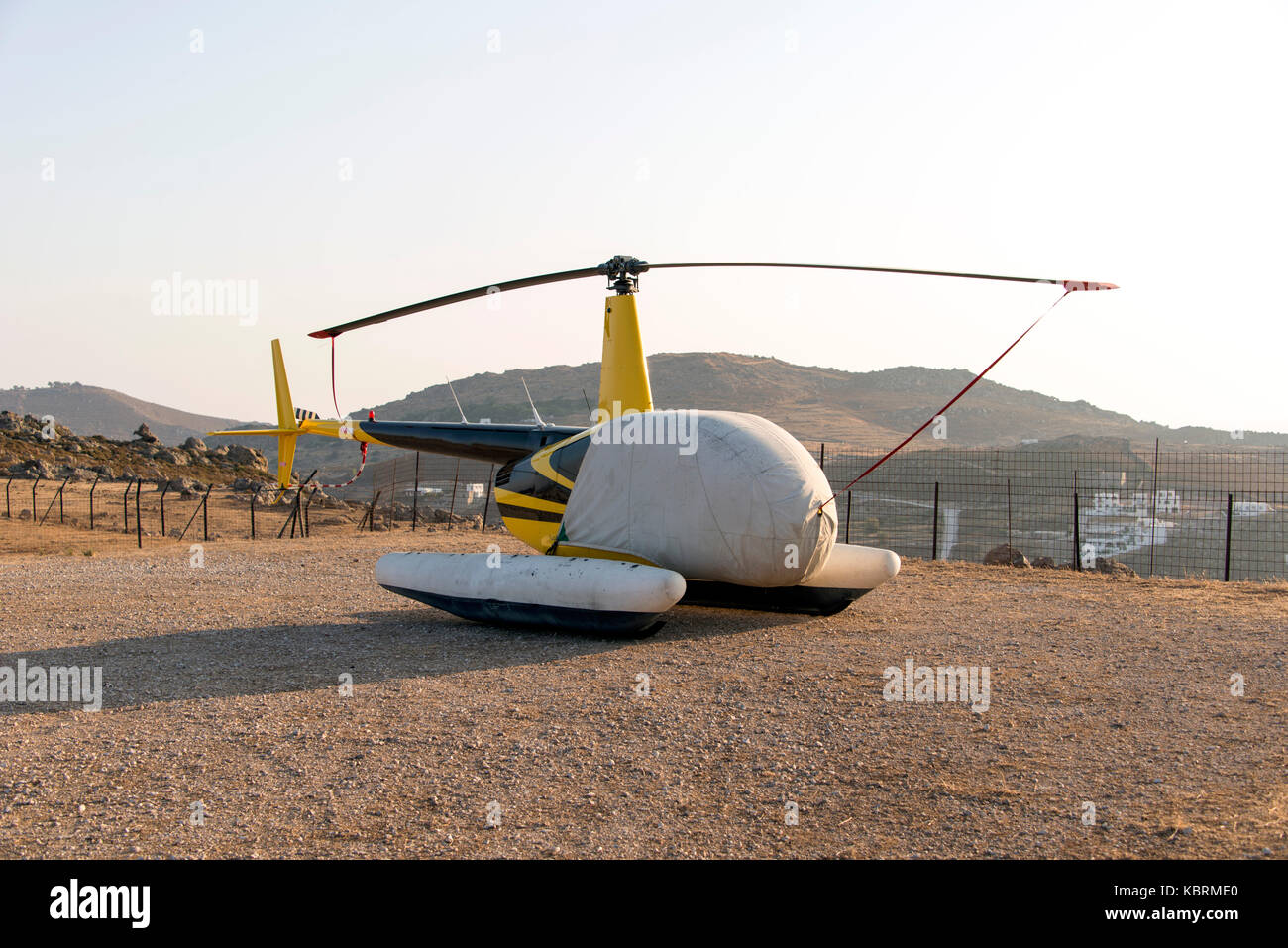 A covered helicopter in a heliport in Greece Stock Photo - Alamy