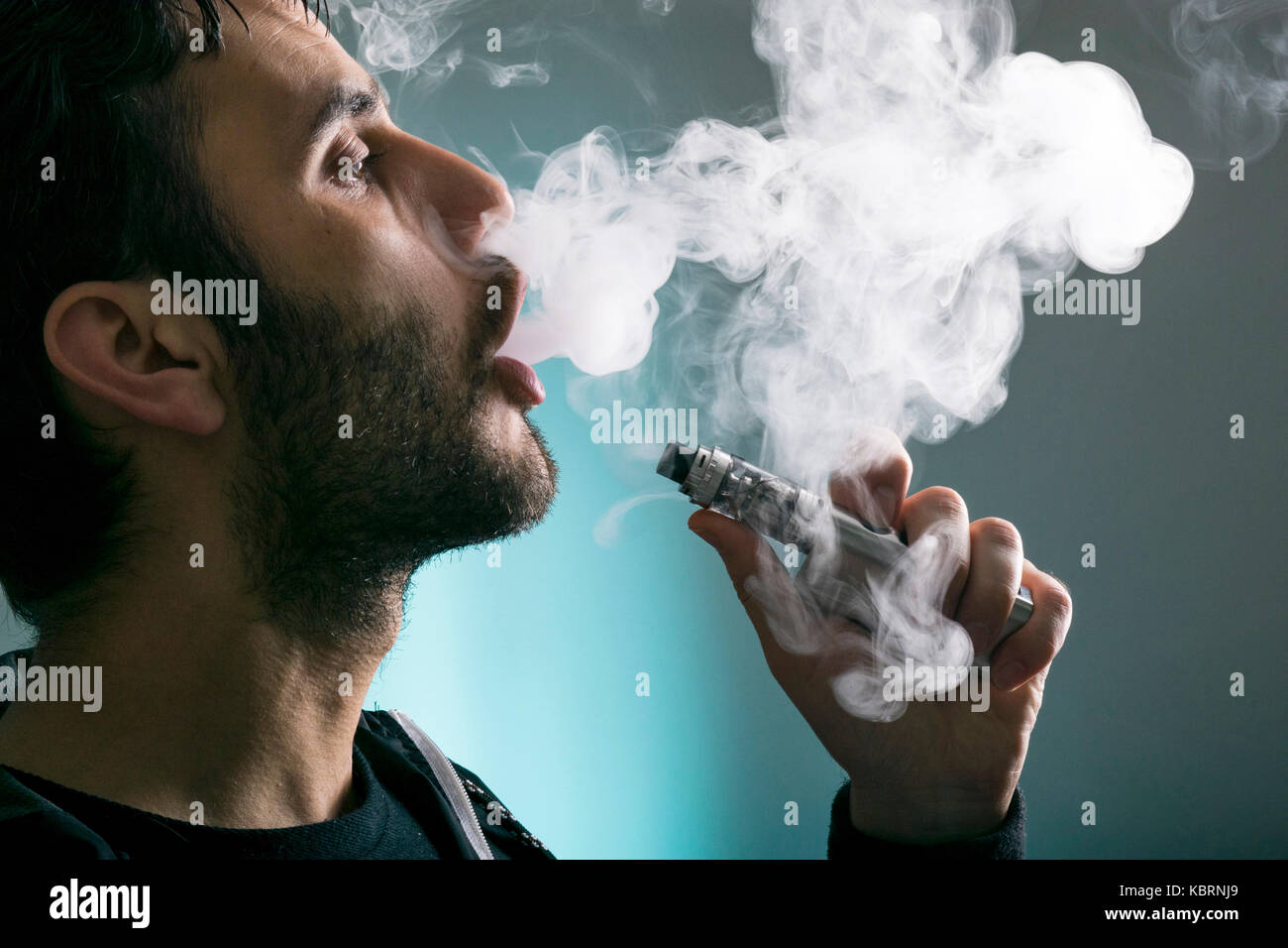 young man vape electronic cigarette cloud by using a mod, smoke tricks ...