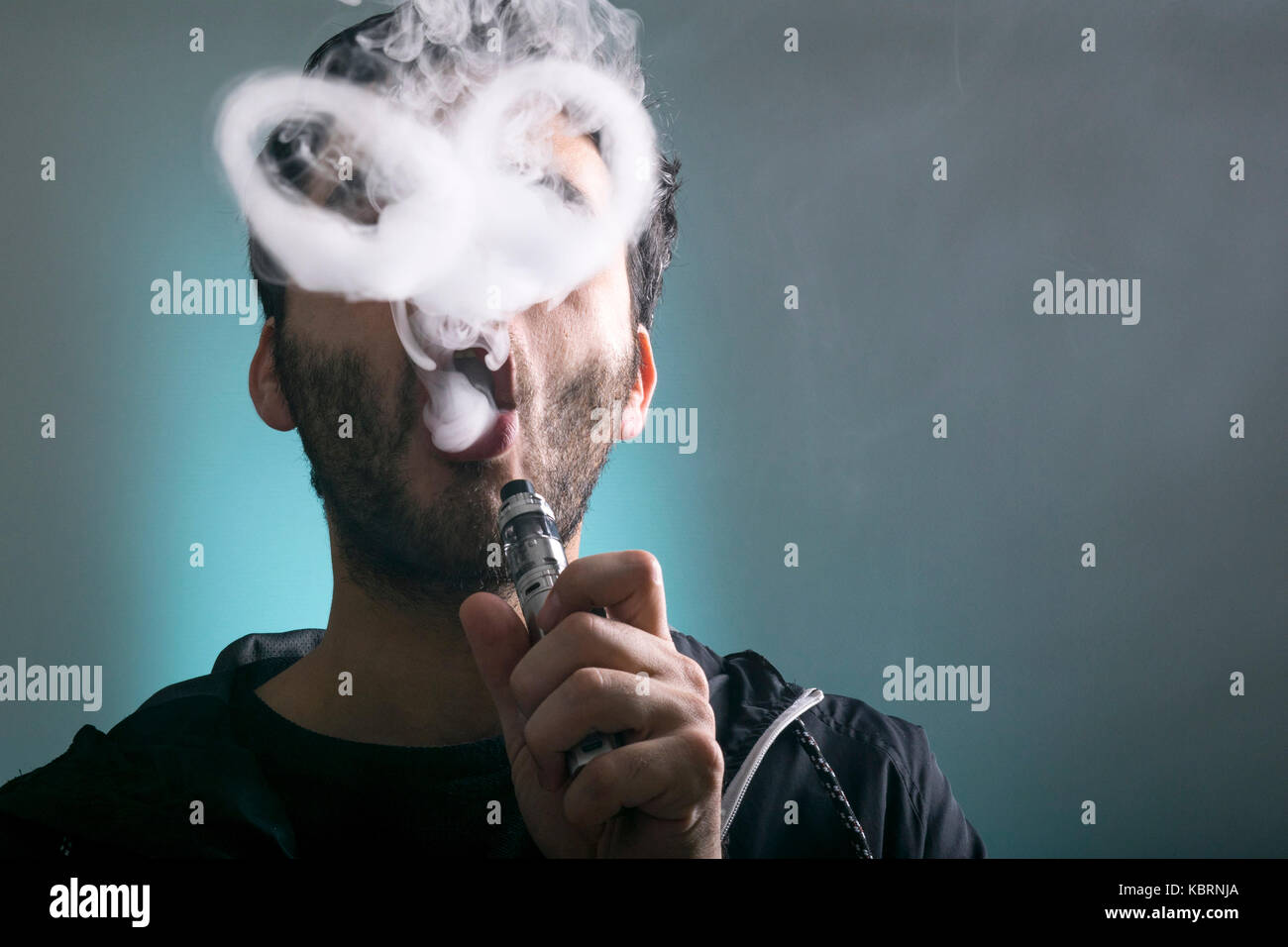 young man vape electronic cigarette cloud by using a mod, smoke tricks ...