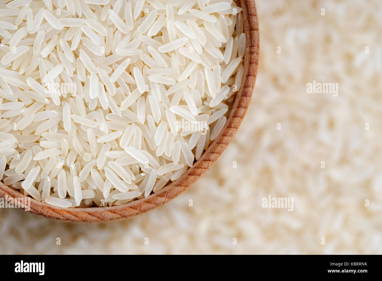 Healthy food. Long parboiled rice in wooden bowl on blurred background ...