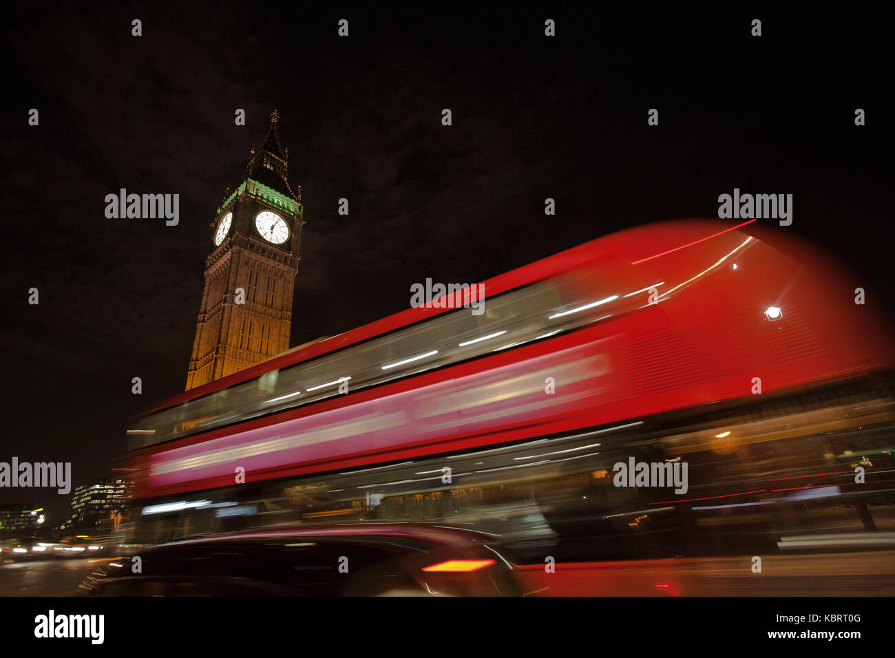 Big Ben with red London bus driving past Stock Photo - Alamy