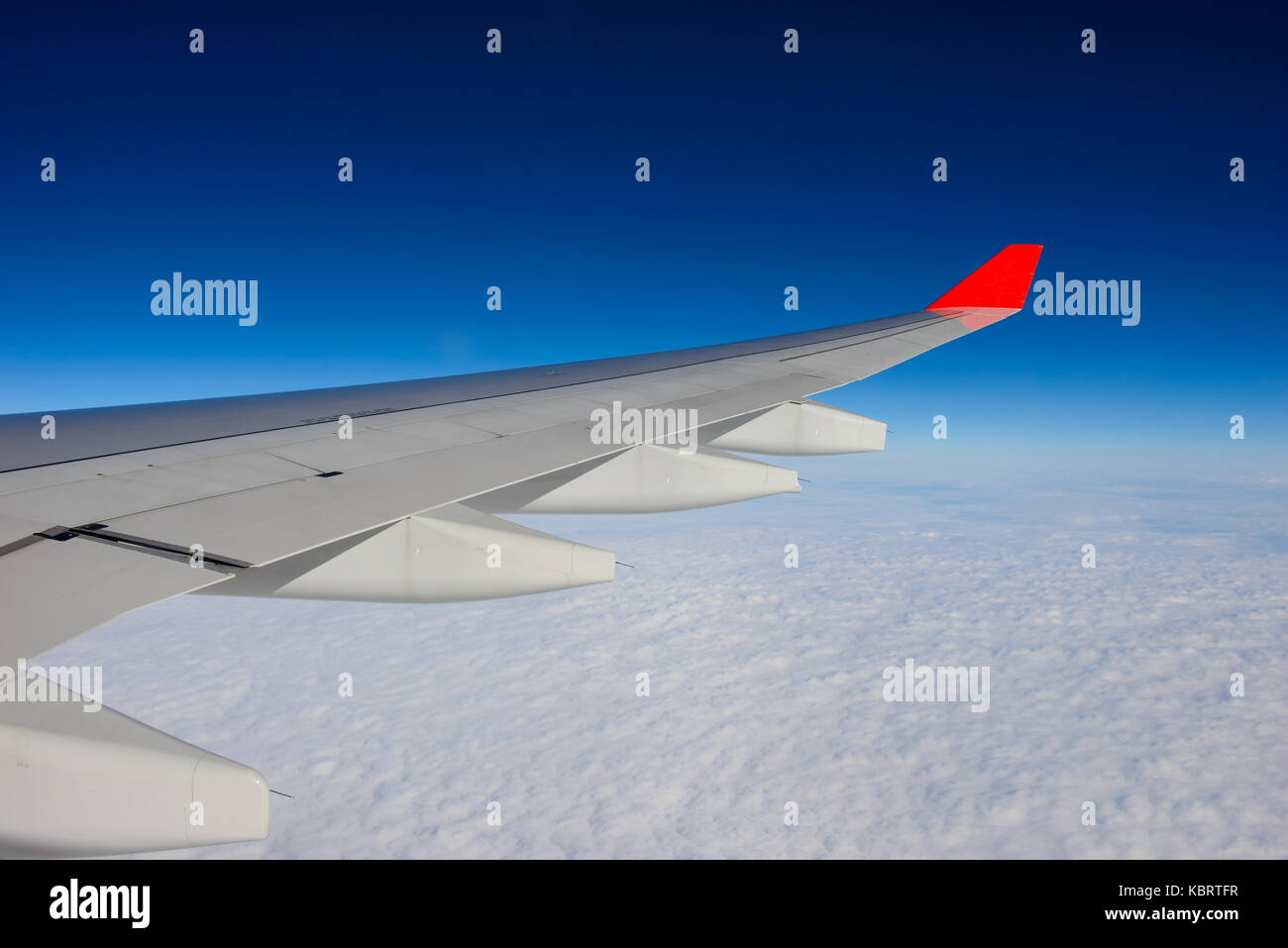 Wing of airplane in the sky red winglet blue sky Stock Photo - Alamy