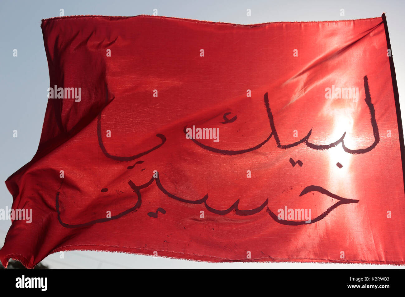 A red flag with Arabic reading,"On your Service Hussein" pictured ...
