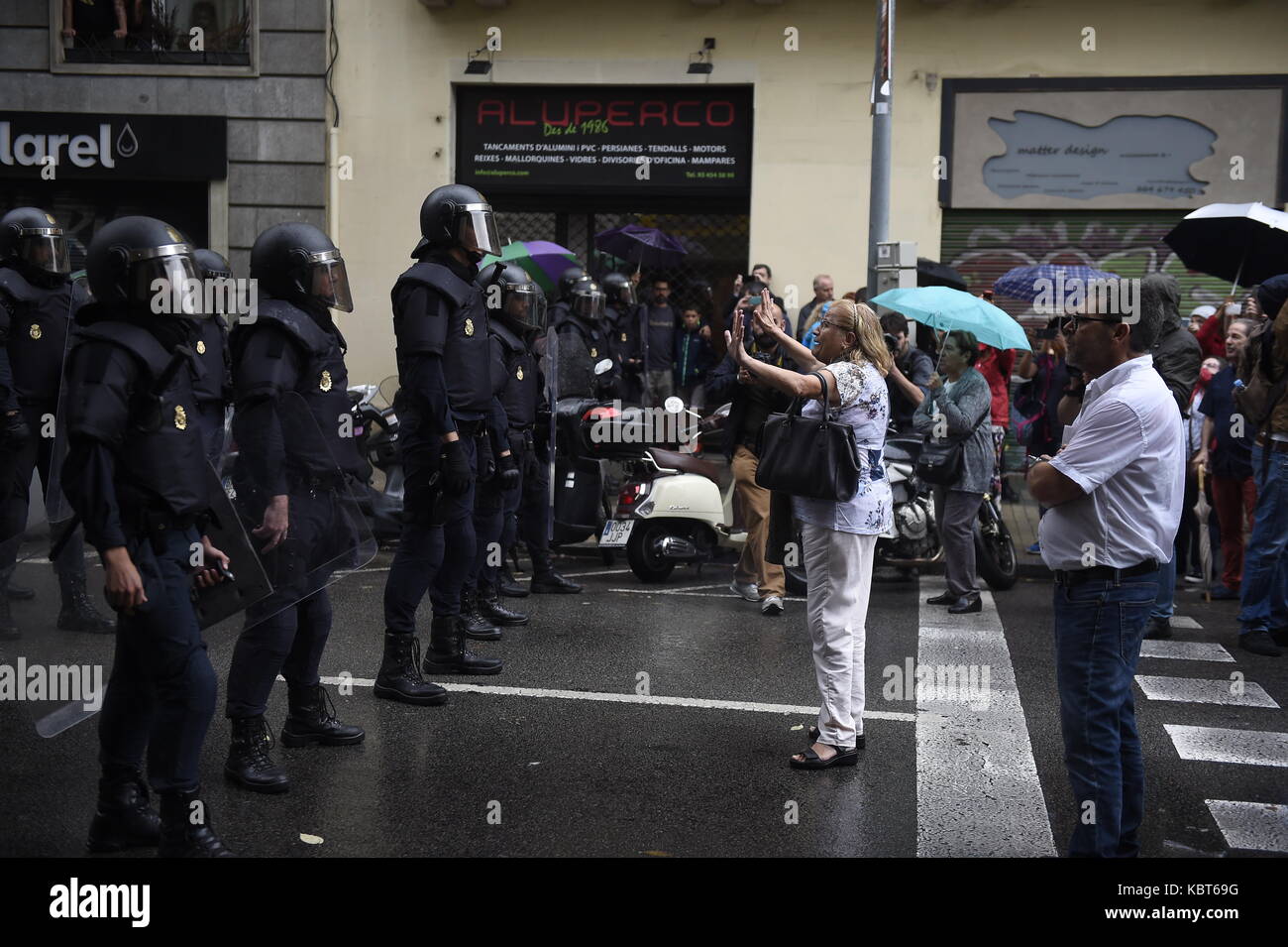 A Spanish National Police officer aims ar rubber-bullet rifle at pro ...