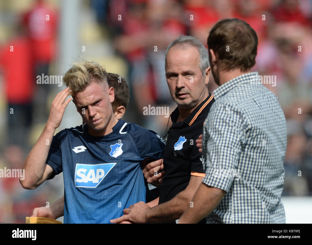 Hoffenheim's team doctor Ralph Kern (c) helps Robin Hack (l) off the ...