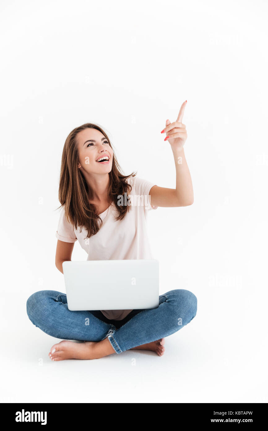 Vertical image of happy brunette woman holding laptop computer and ...