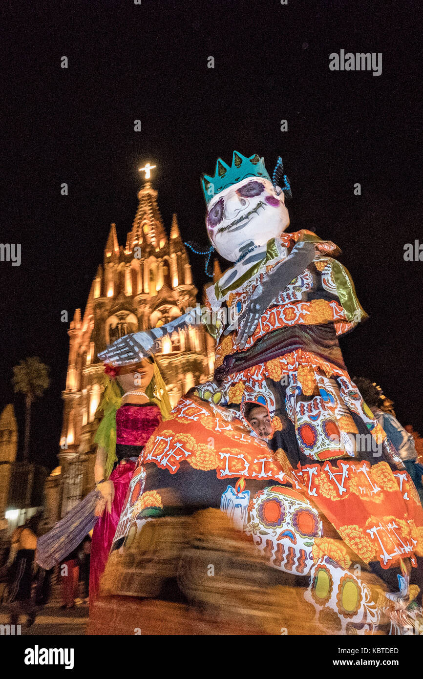 Giant paper-mache puppets called mojigangas dance past the Parroquia ...