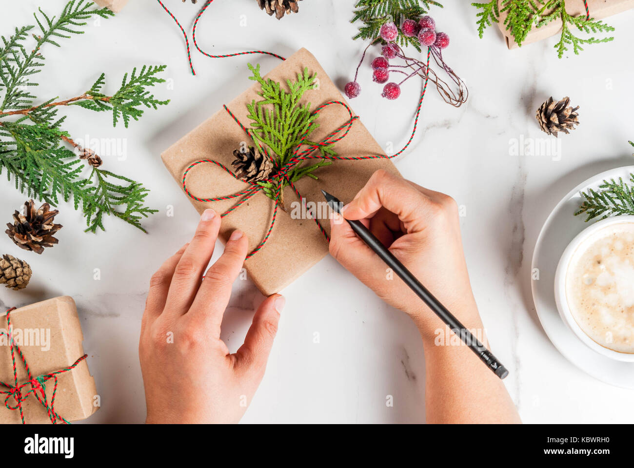 Woman write wishes on Christmas gift or present box, decorated with ...