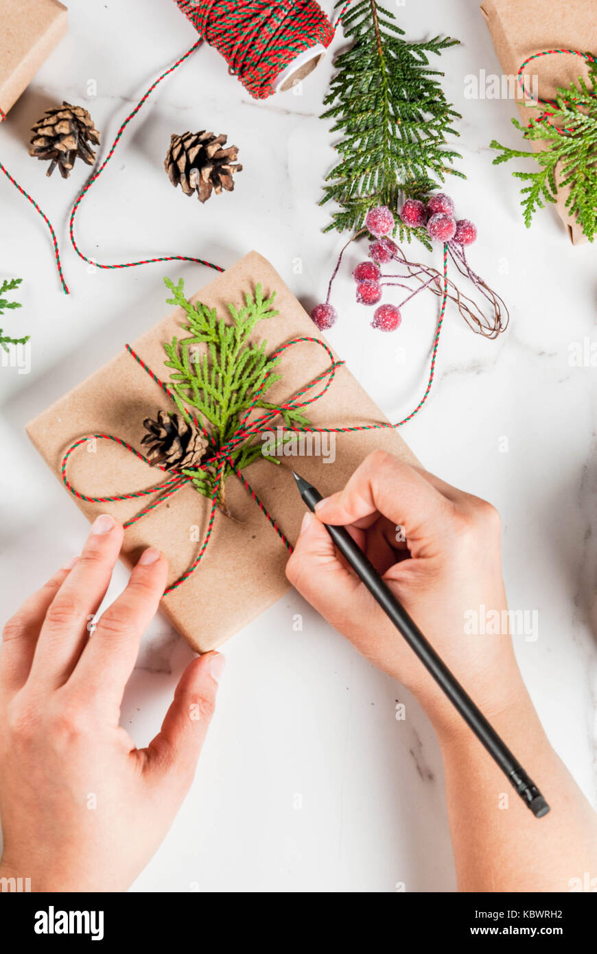 Woman write wishes on Christmas gift or present box, decorated with ...