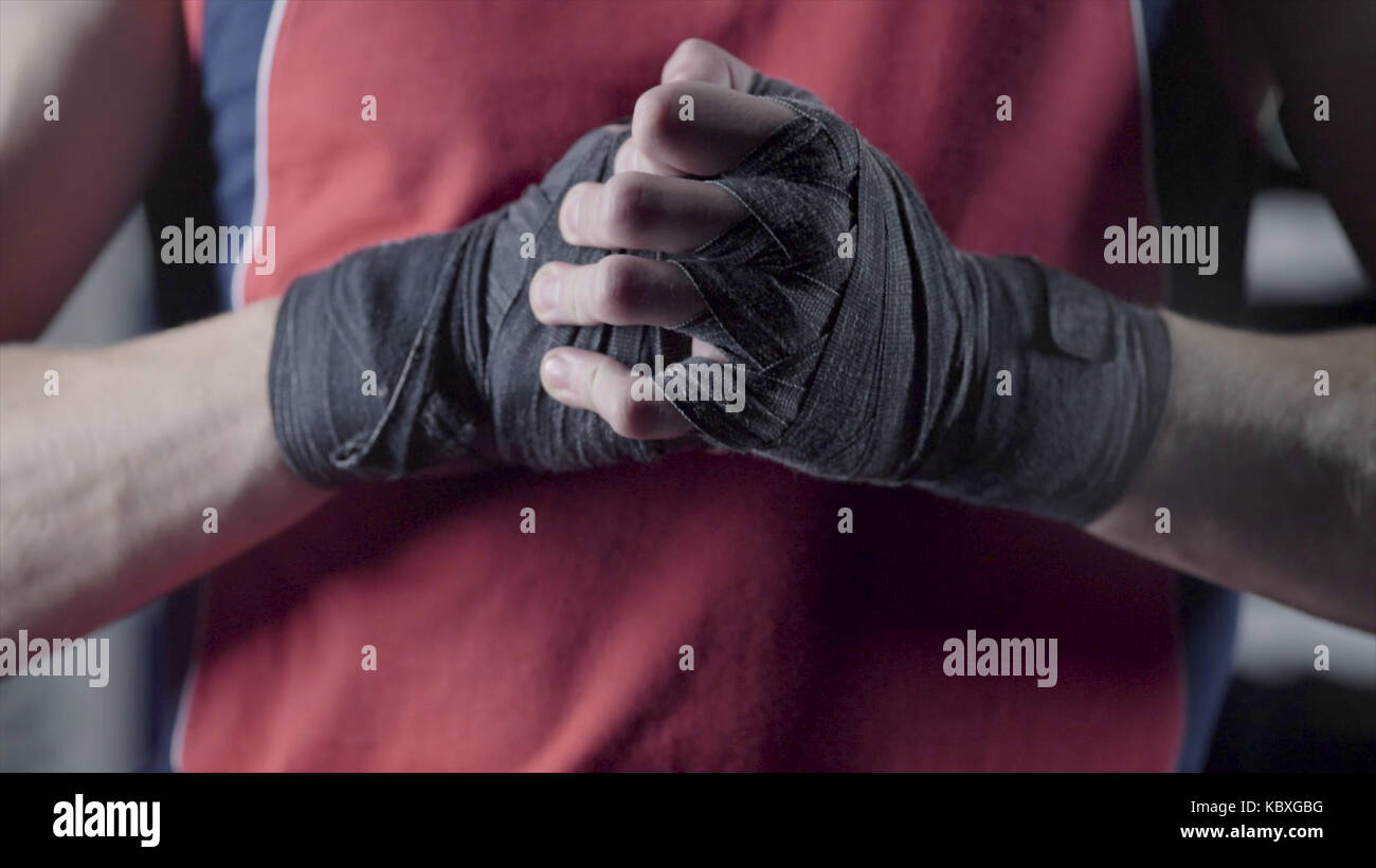 Man flexing his fists before a fight. Close-up of a young Thai boxer ...